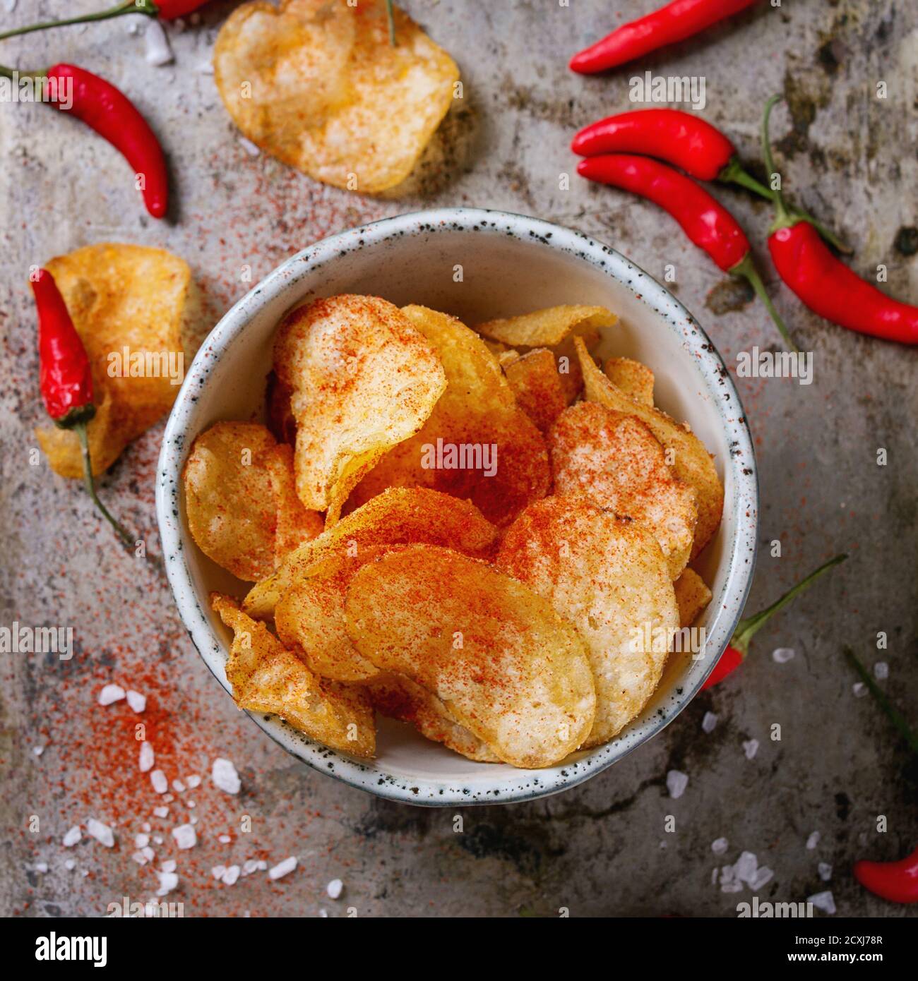 Bowl of spicy potato chips with sea salt and red hot chili peppers ...