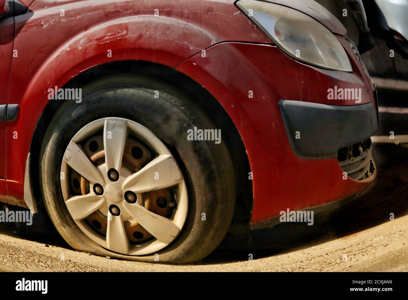View of a car tyre punctured. Deflated trye are common problems with ...