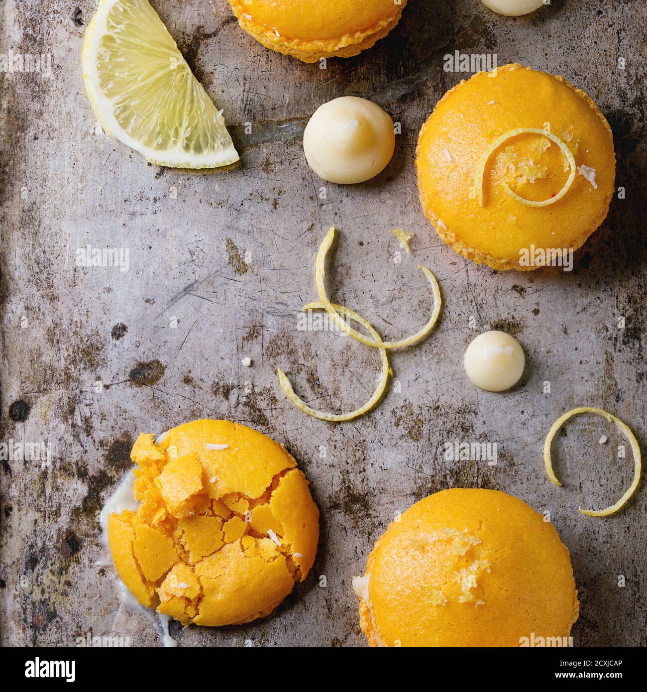 Whole and broken orange lemon homemade macaroons with chopped white ...