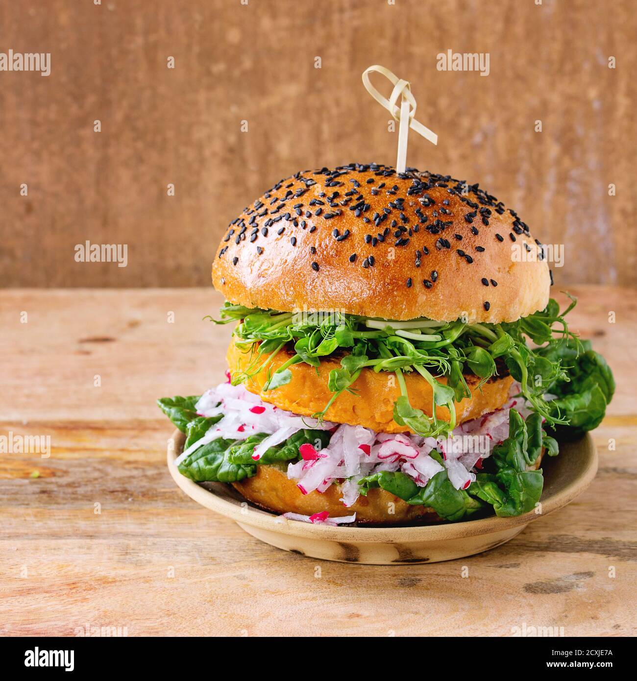Homemade veggie sweet potato burger with fresh radish and pea sprouts ...