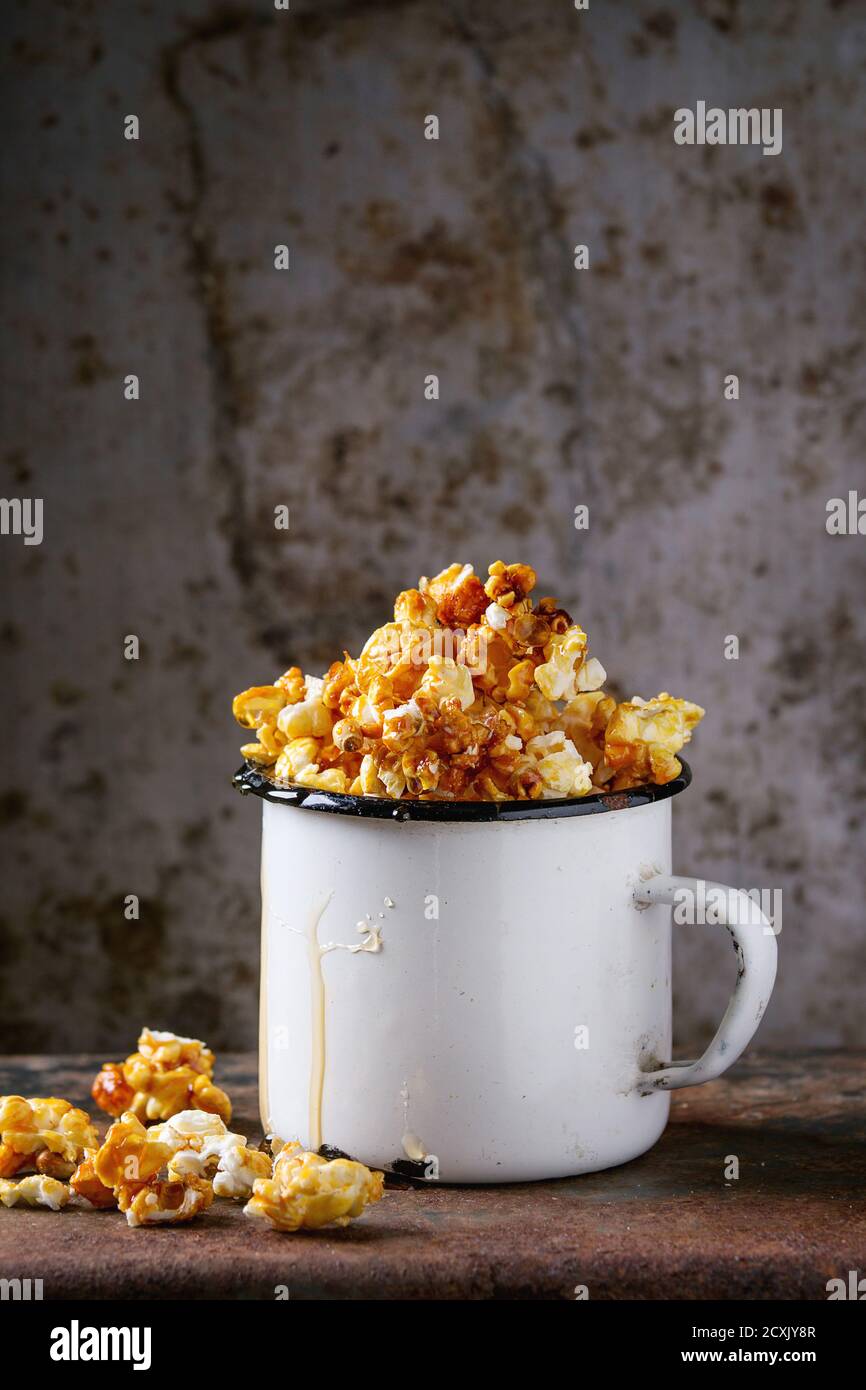 Caramelized sweet popcorn served in vintage enameled white mug with ...