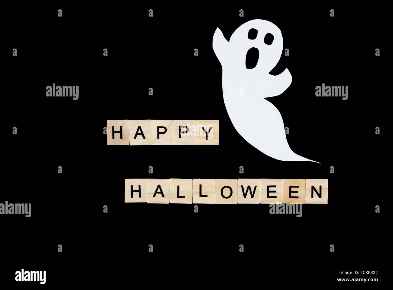 Cut out paper ghost and wooden letters Happy Halloween on black ...