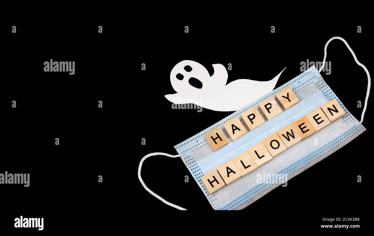 Cut out paper ghost, medical mask and words Happy Halloween on black ...