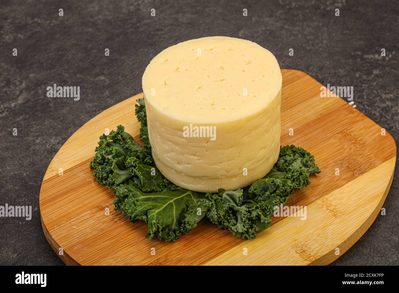 Yellow round dairy soft cheese piece Stock Photo - Alamy