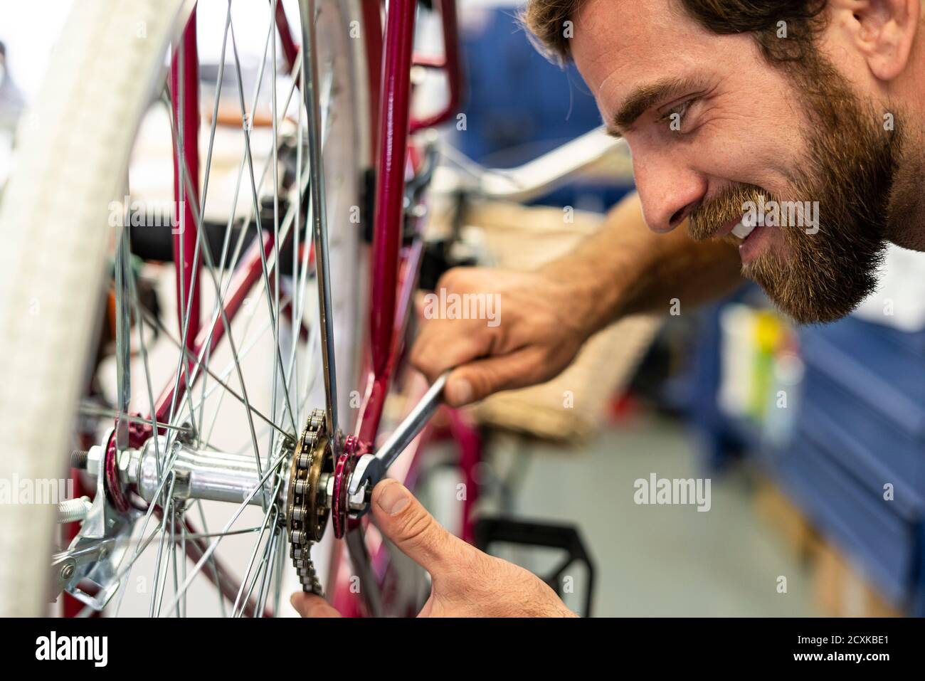 Mechanic repairing bicycle wheel in workshop Stock Photo - Alamy