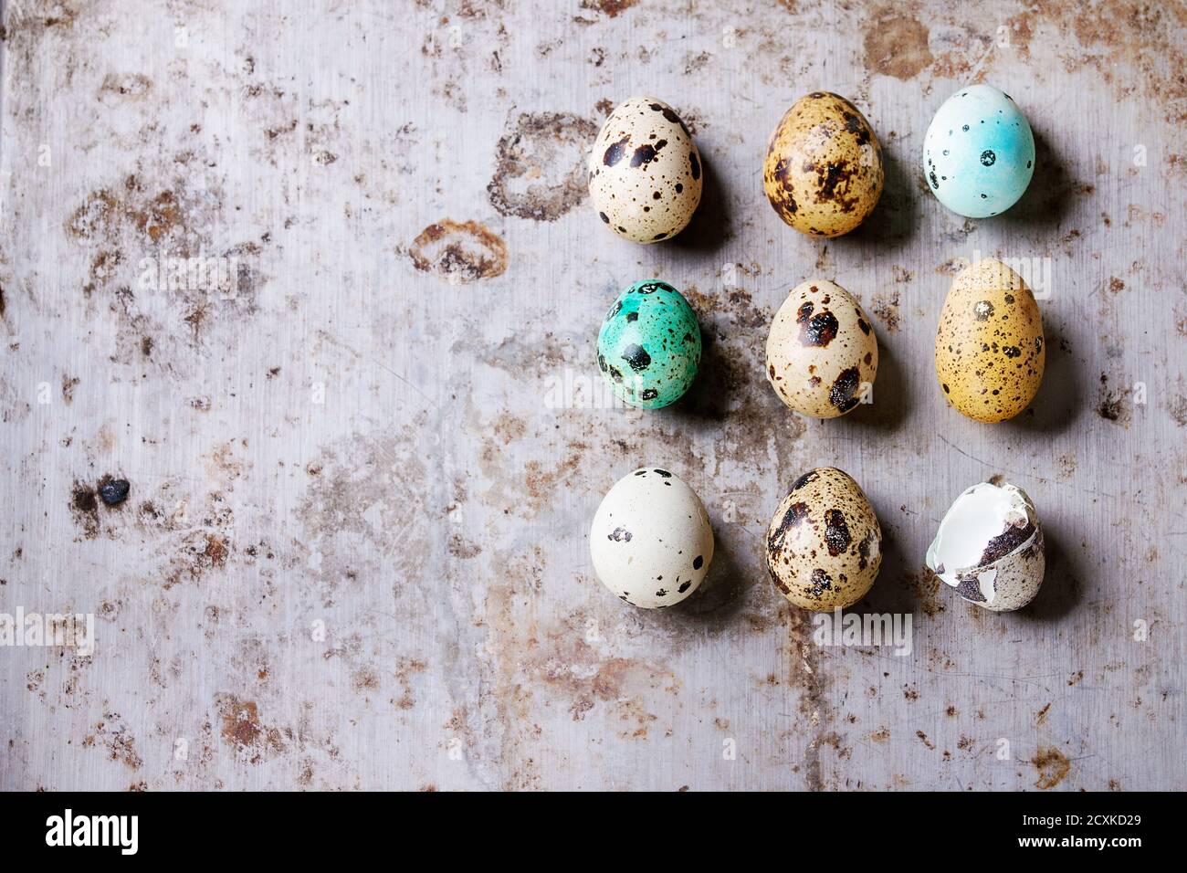 Decor whole and broken colorful Easter quail eggs standing in row rusty ...