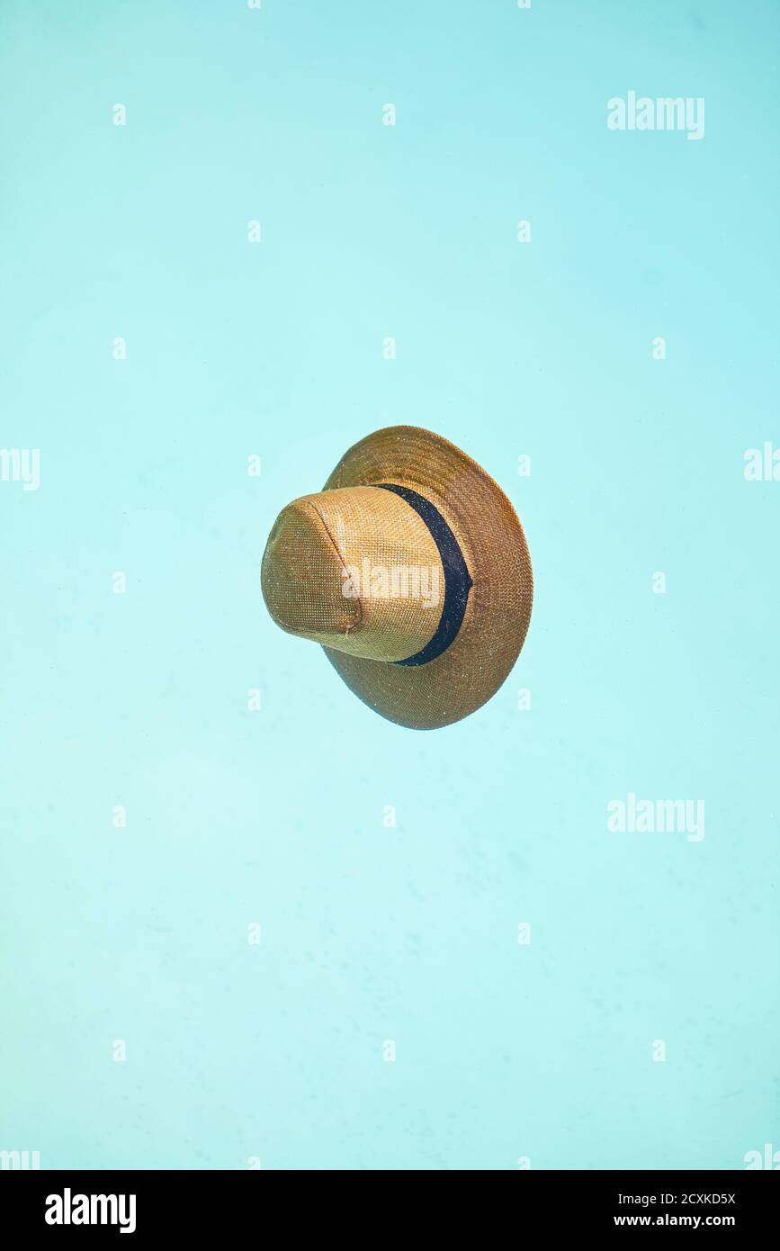 Straw hat floating on swimming pool Stock Photo - Alamy