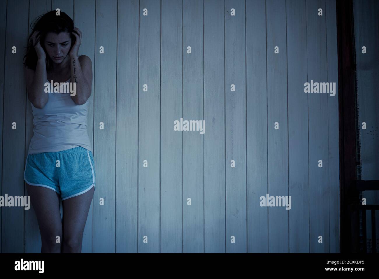 Sad young woman standing in bedroom Stock Photo - Alamy