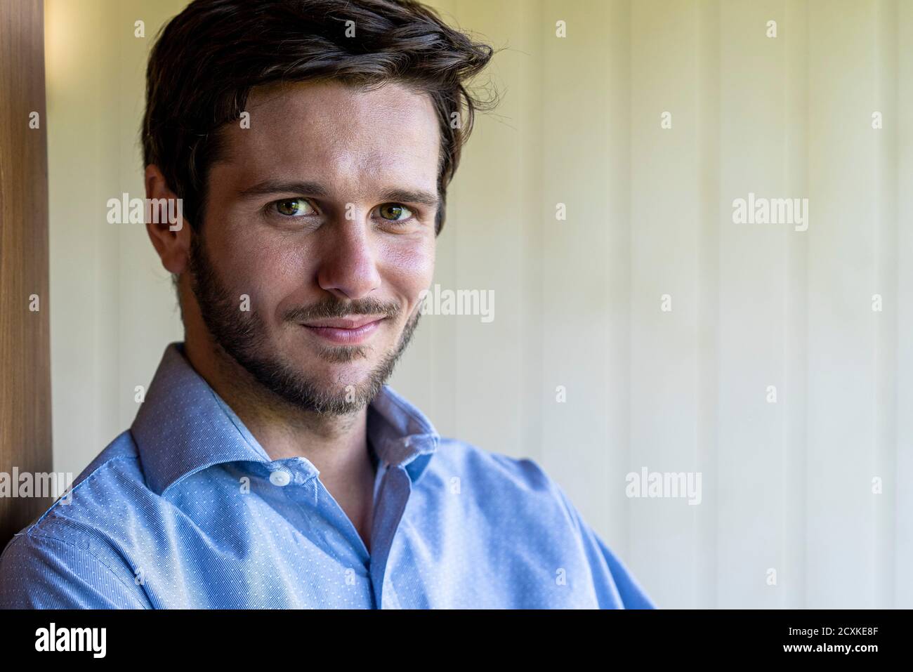 Portrait of young man standing in house Stock Photo - Alamy