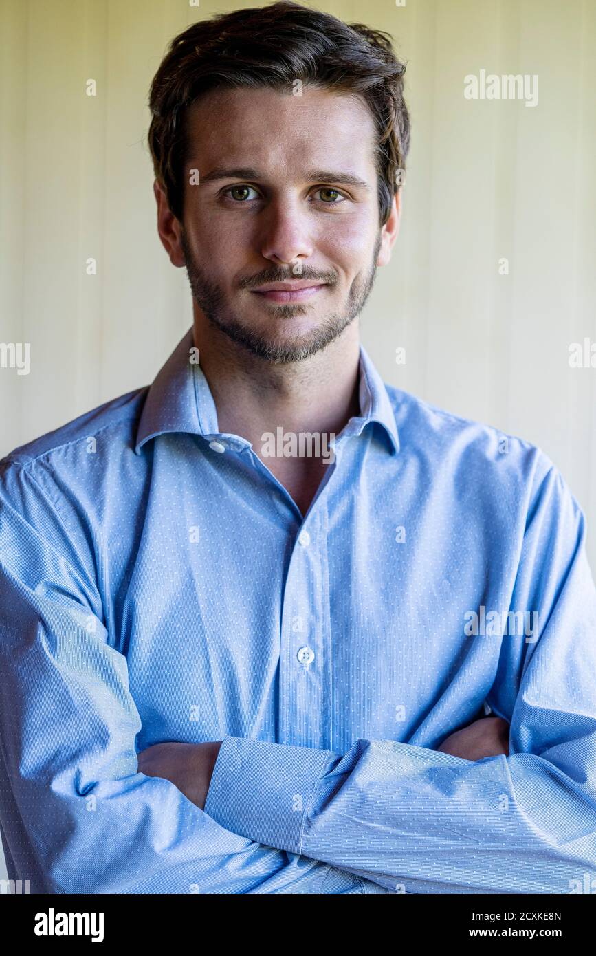 Portrait of young man standing in house Stock Photo - Alamy