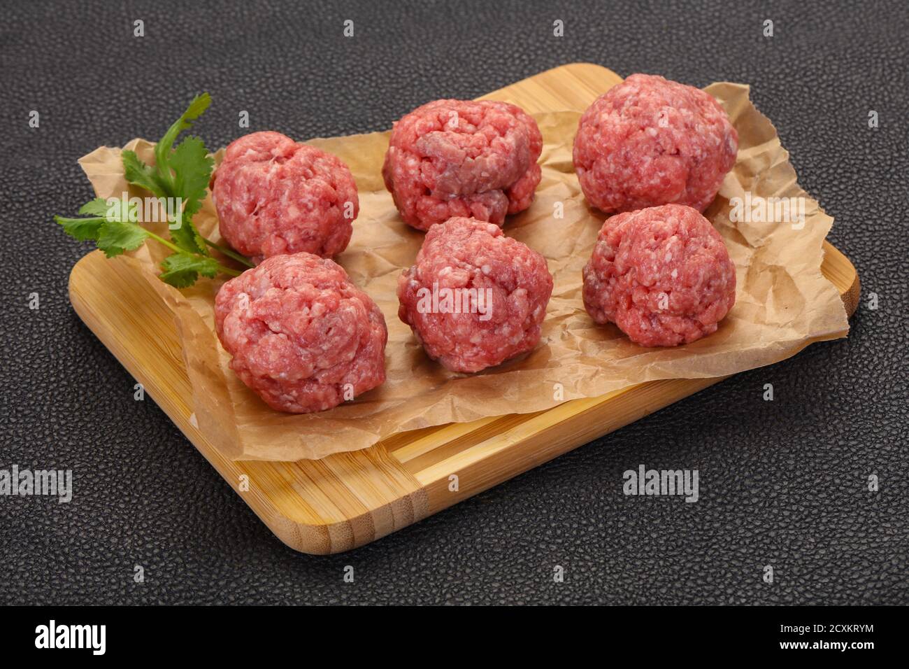 Raw meatball over wooden background ready for cooking Stock Photo - Alamy