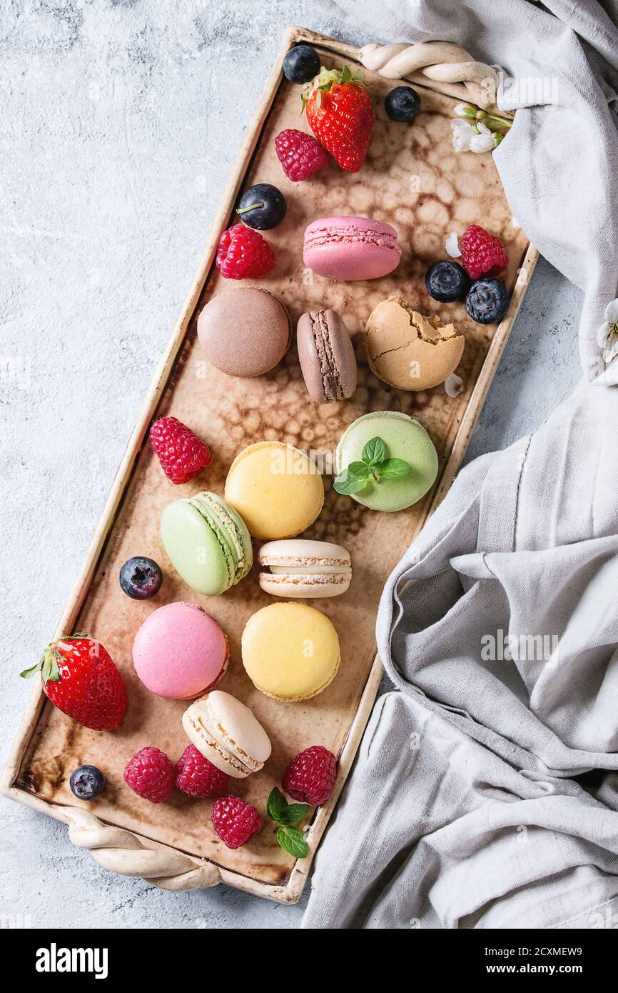 Variety of colorful french sweet dessert macaron macaroons with different fillings served on ...