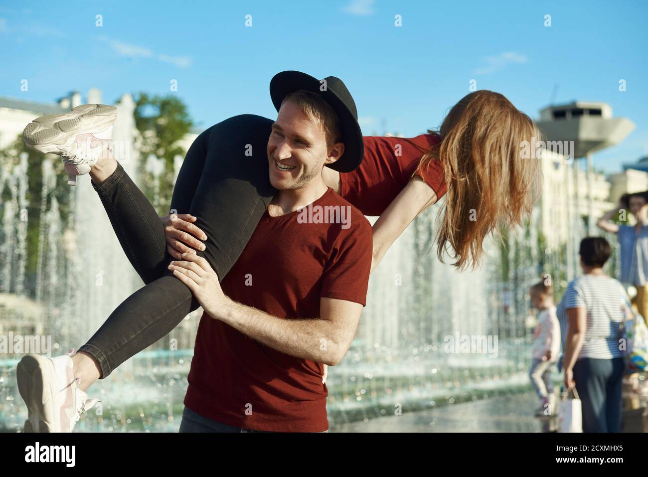 The man is holding young woman on the shoulder. The man holds the woman ...
