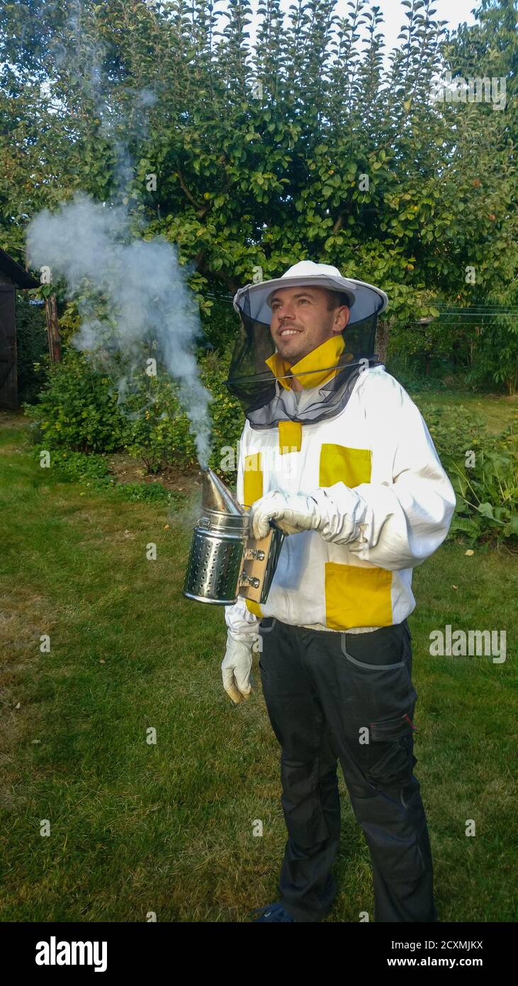 Beekeeper with smoker Stock Photo - Alamy
