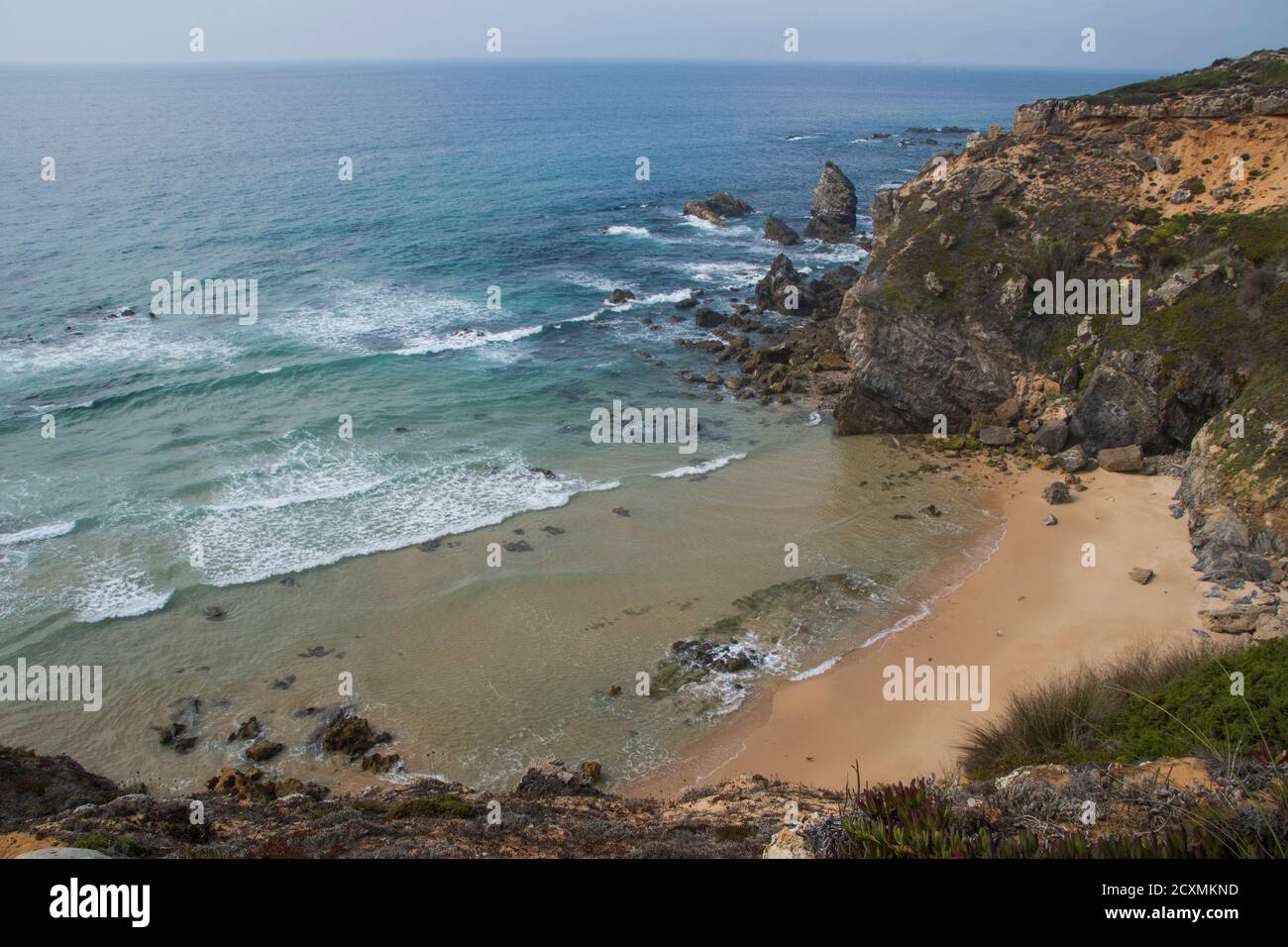 Small beach landscape with wave lines coming ashore and cliffs entering ...