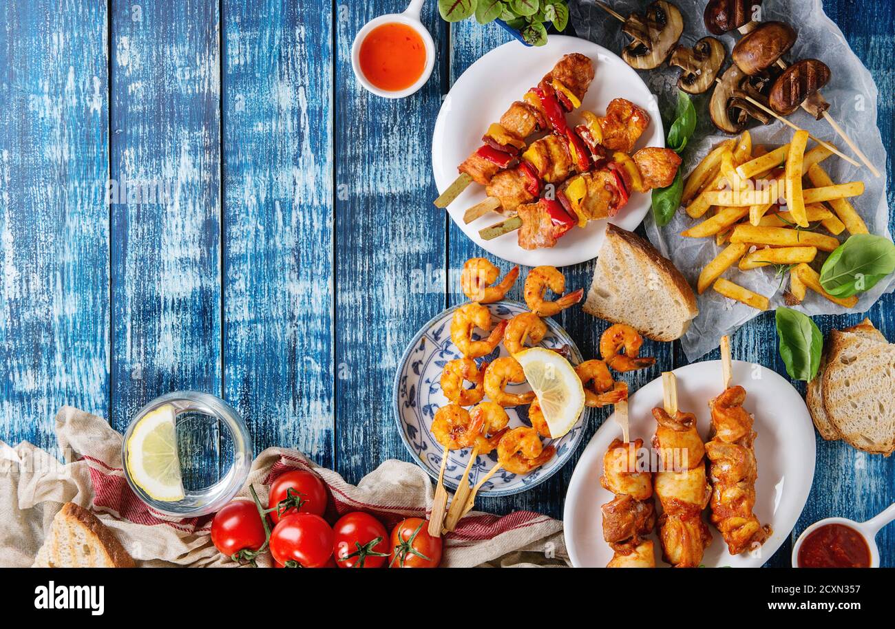 Variety of BBQ snack lunch. Plates grilled spicy prawn kebabs, chicken ...