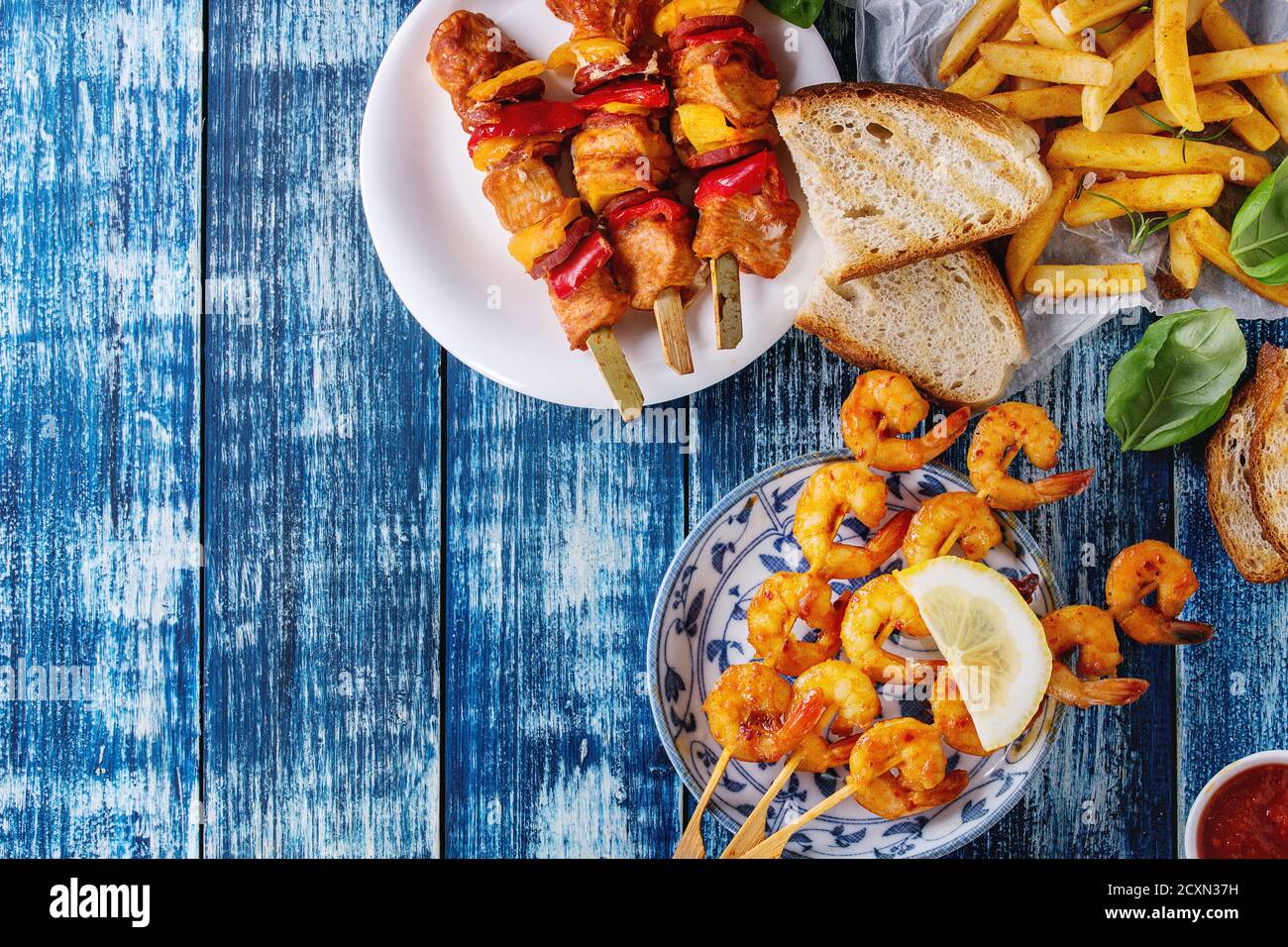 Variety of BBQ snack lunch. Plates grilled spicy prawn kebabs, chicken ...