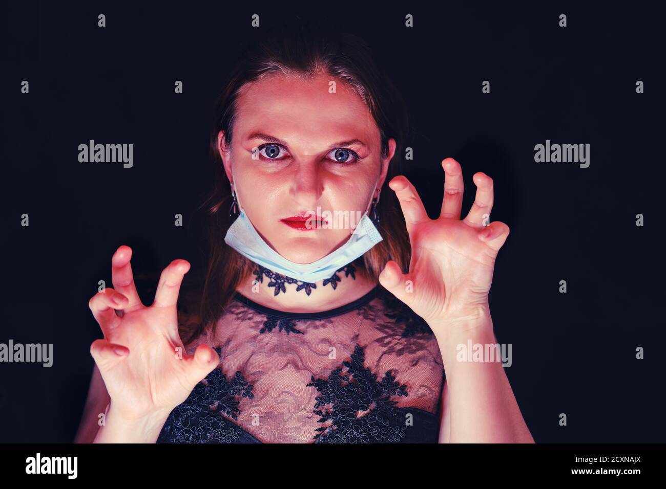 Angry look of a vamp woman with a medical mask on her face. Girl with ...