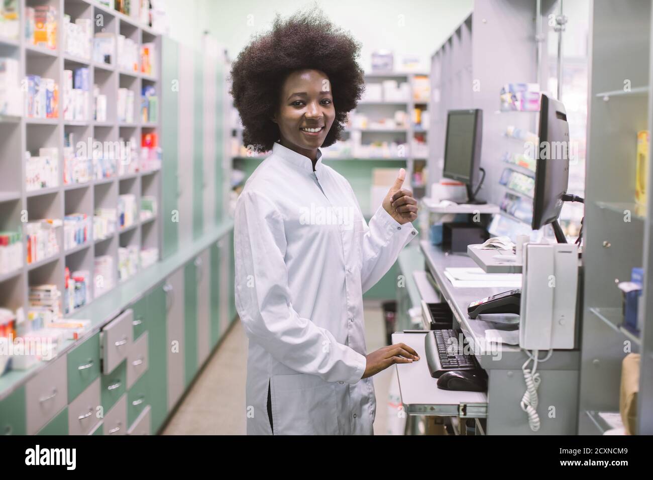African-american woman pharmacist on her workplace in modern drugstore ...