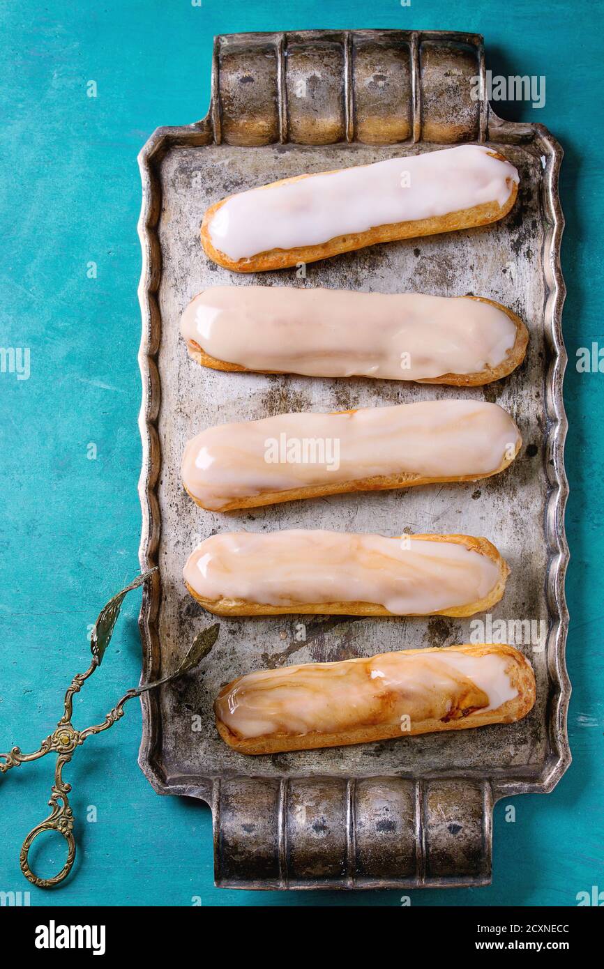 Homemade Coffee eclairs with different glaze on vintage metal tray over ...