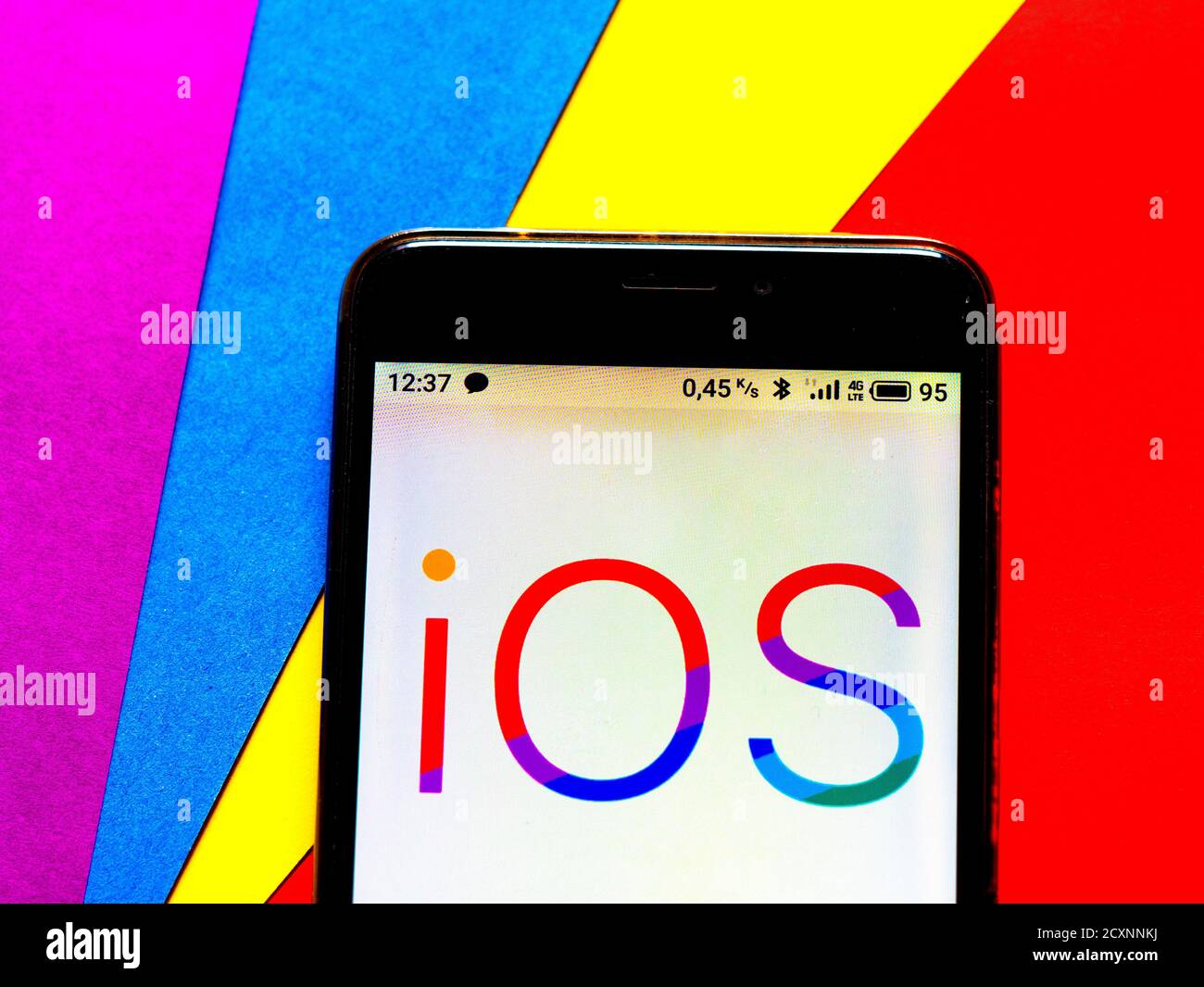 In this photo illustration a iOS logo is seen displayed on a smartphone ...