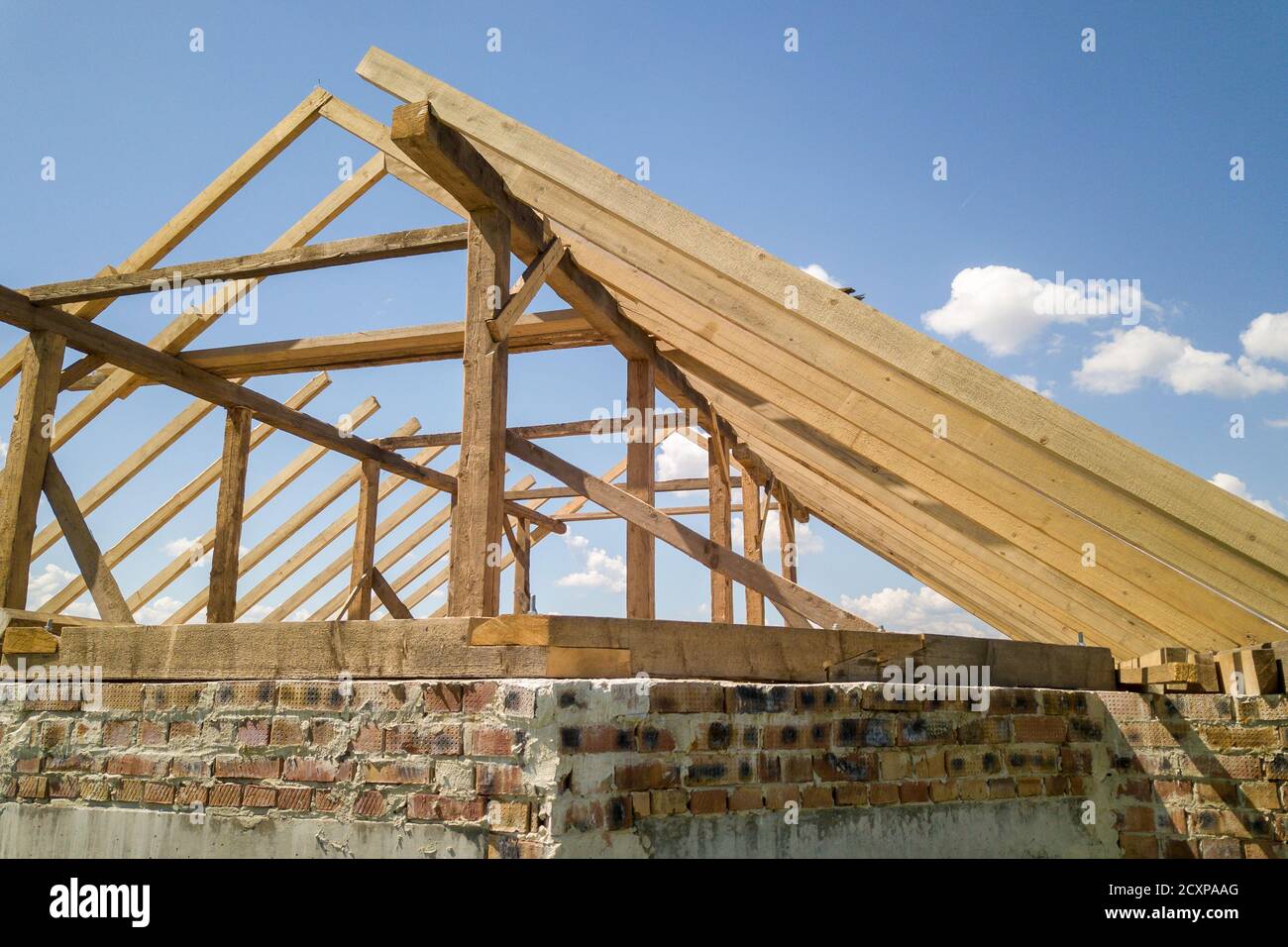 Aerial view of unfinished house with wooden roof frame structure under ...