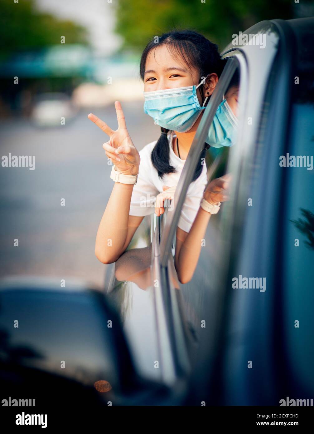 asian teenager wearing protection mask sitting in passenger car and ...