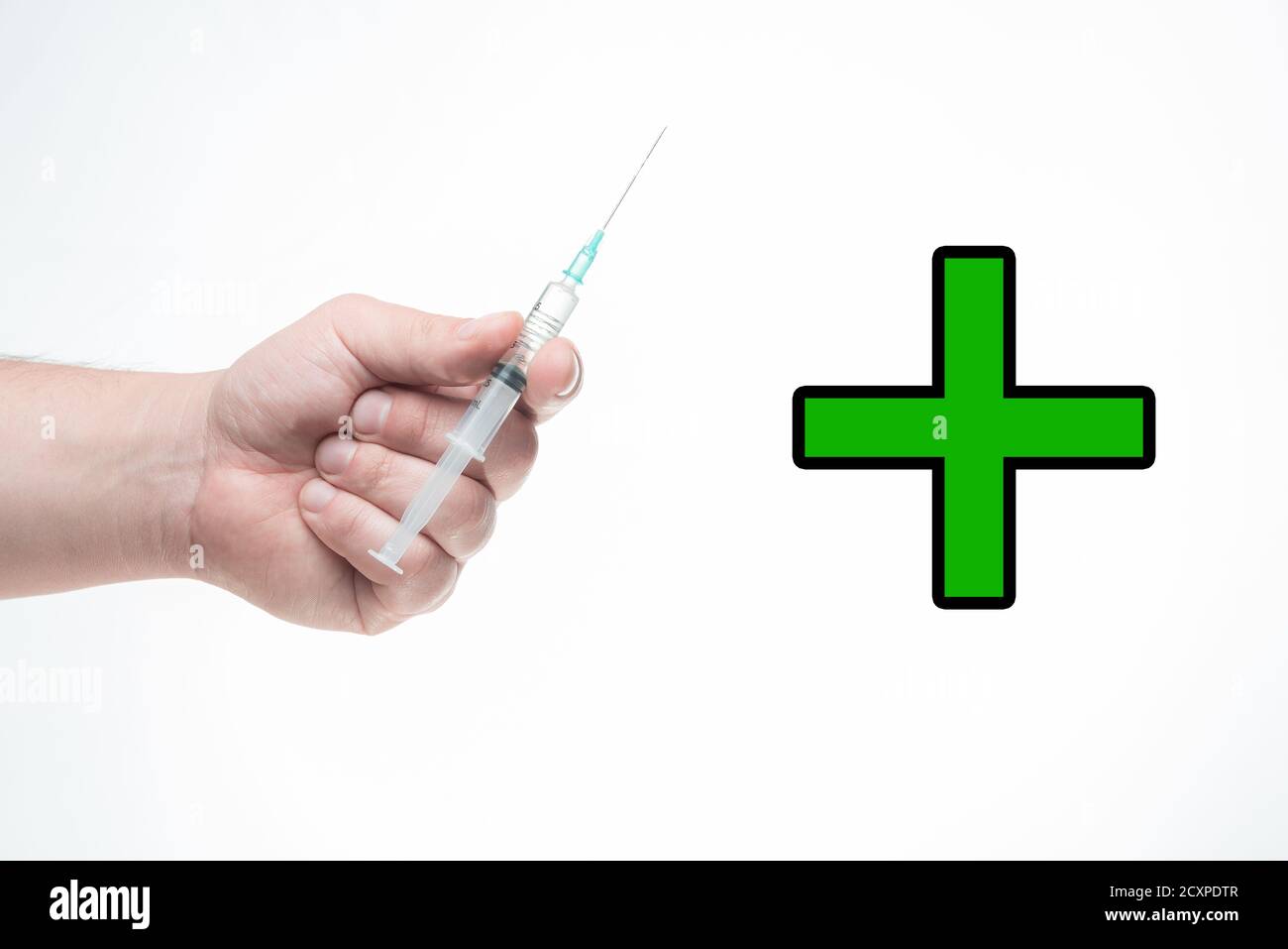 Closeup shot of a syringe on hand and green cross isolated on white ...