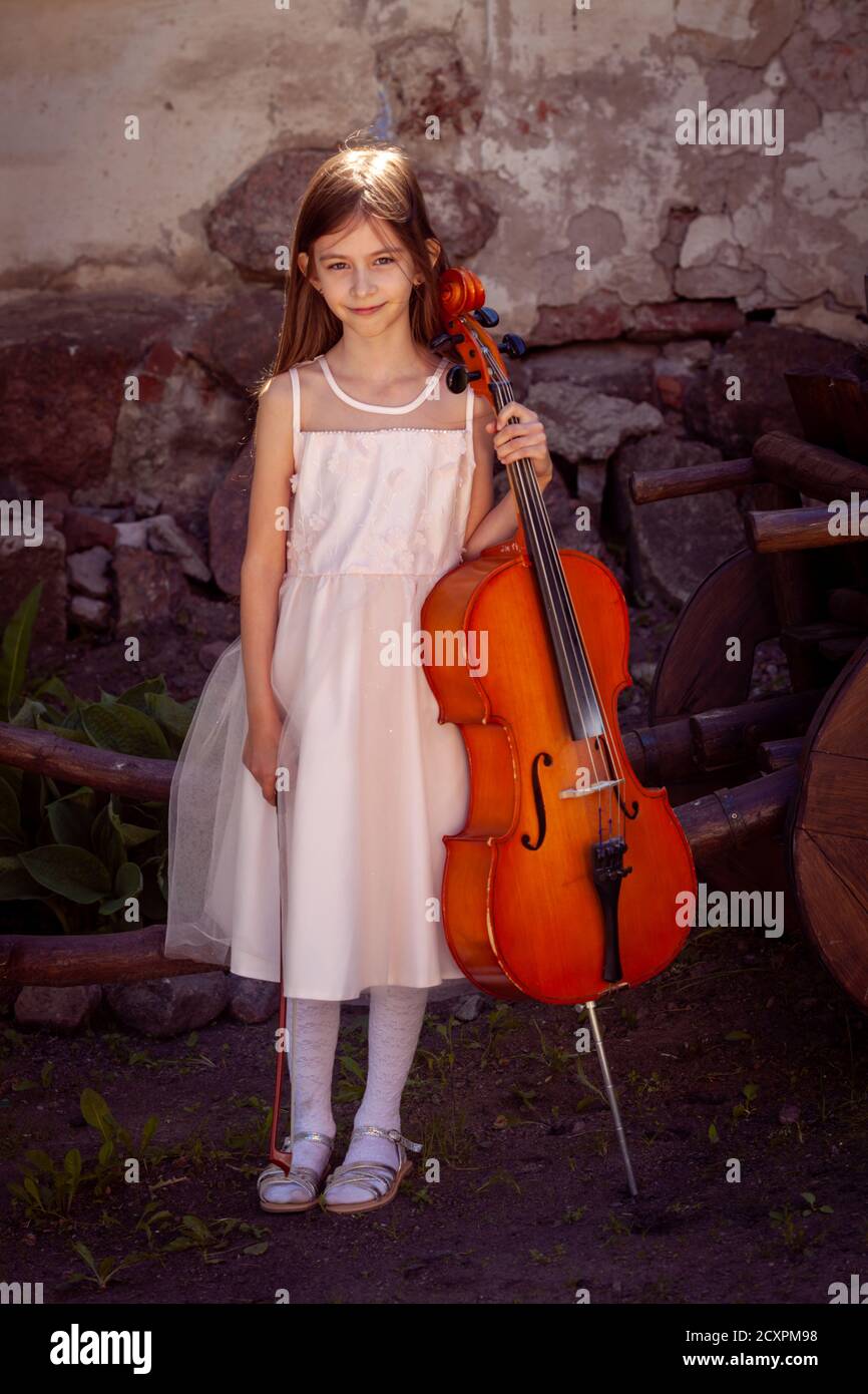 beautiful girl in a pink dress with a cello Stock Photo - Alamy