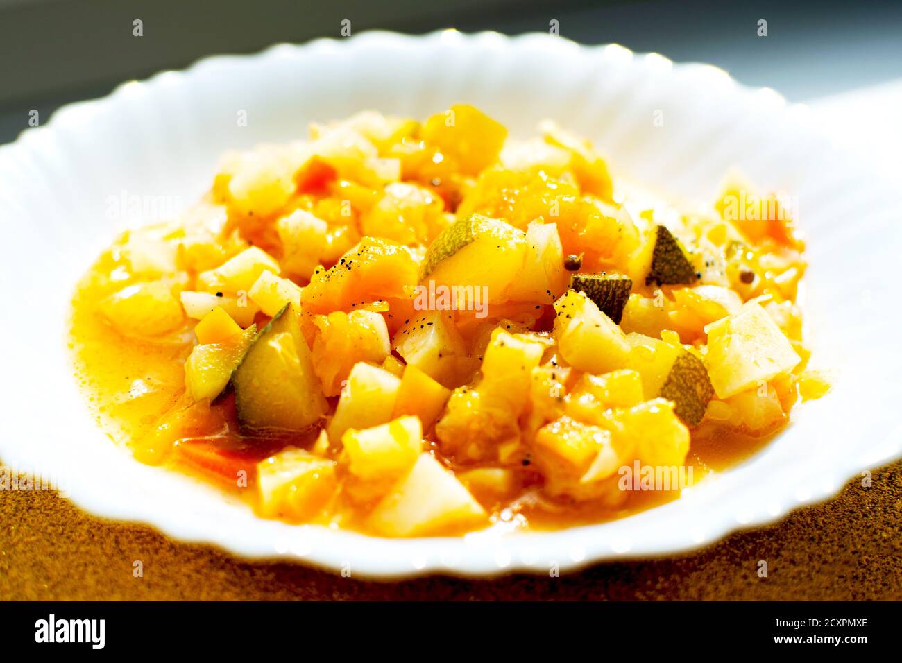 Mix of stewed vegetables on a white plate in cafe. Vegetable stew in ...