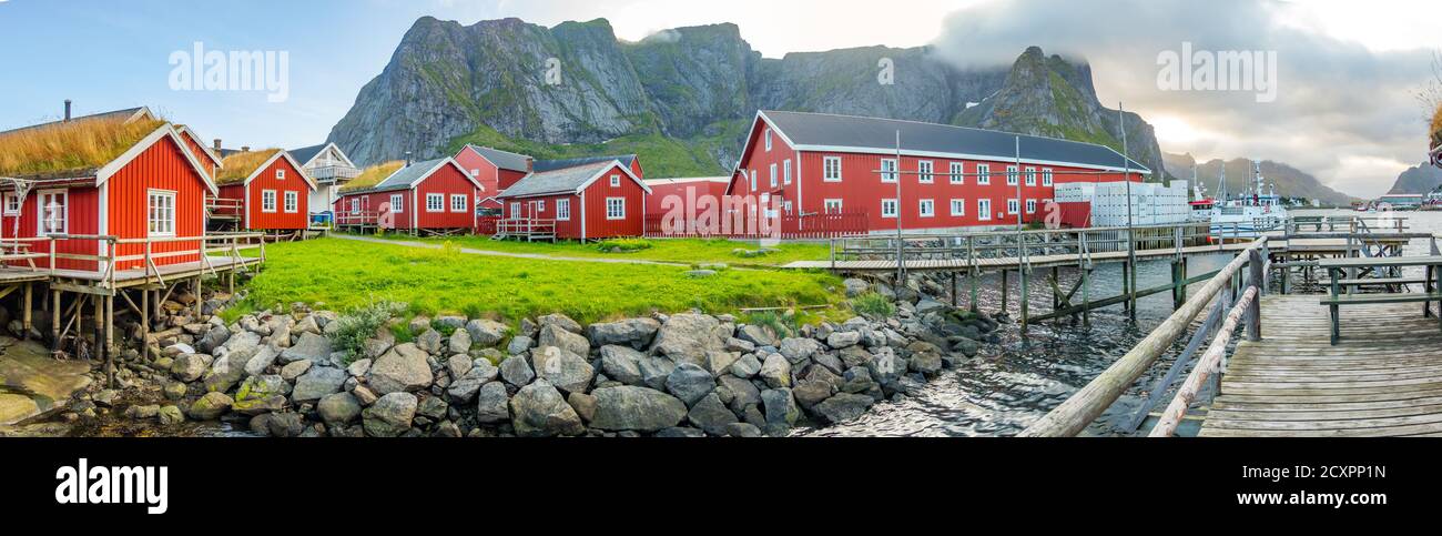 Traditional, red, wooden houses in Reine with the Reinebringen hill in ...