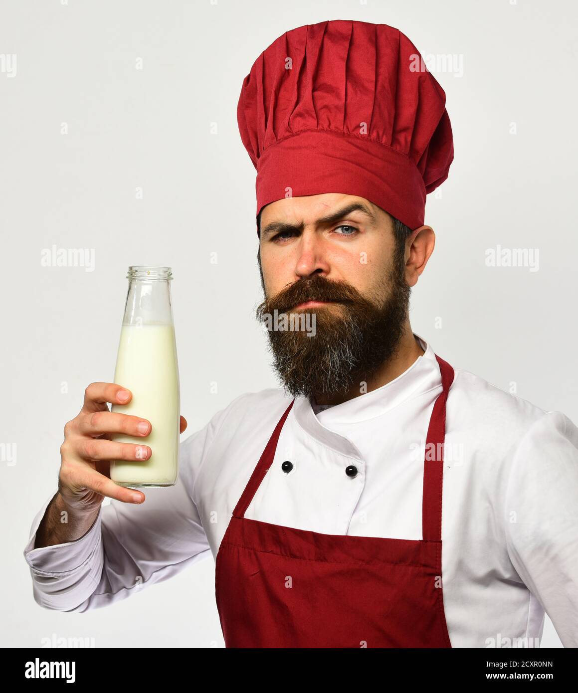 Man with beard holds bottle of milk on white background. Homemade food ...