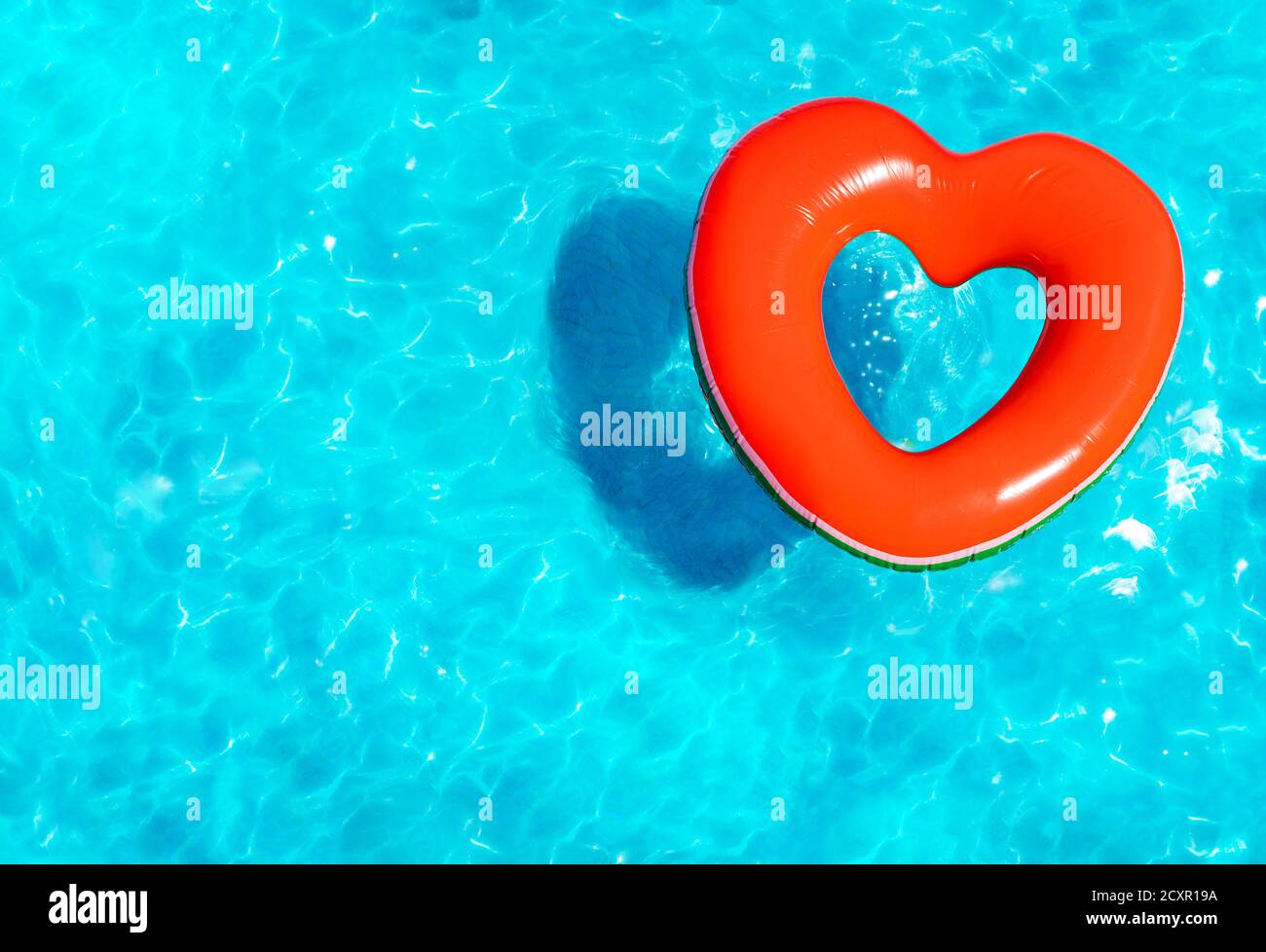 Inflatable red heart buoy swim in the swimming pool view from above ...
