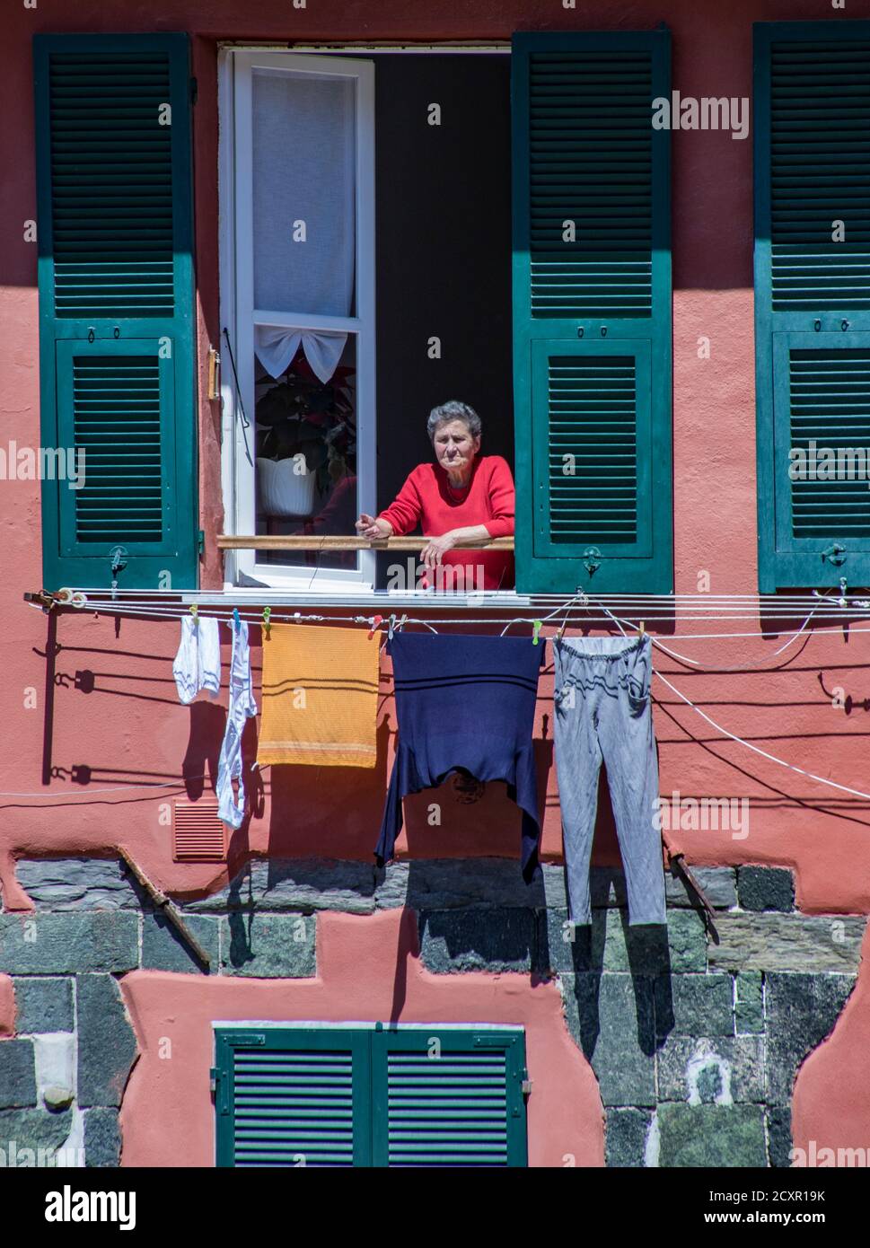 Vernazza, Italy - April 28, 2017 - A woman looks out her apartment ...