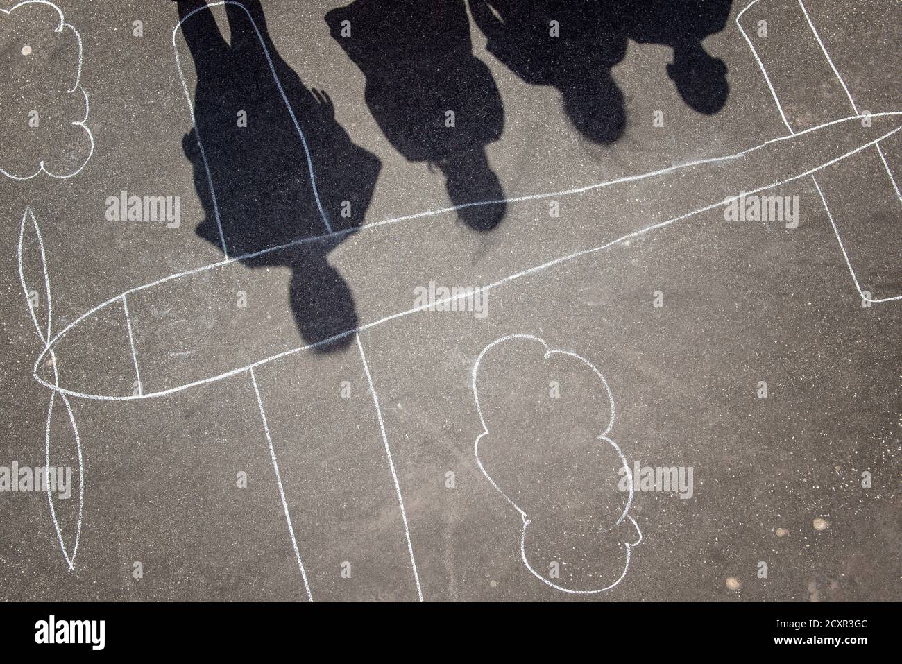 Kids shadows over a chalk drawn airplane Stock Photo - Alamy