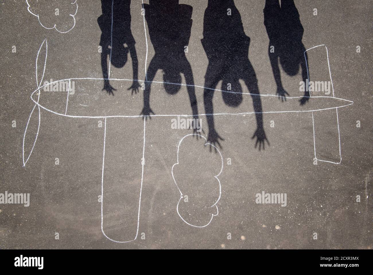 Kids shadows over a chalk drawn airplane Stock Photo - Alamy