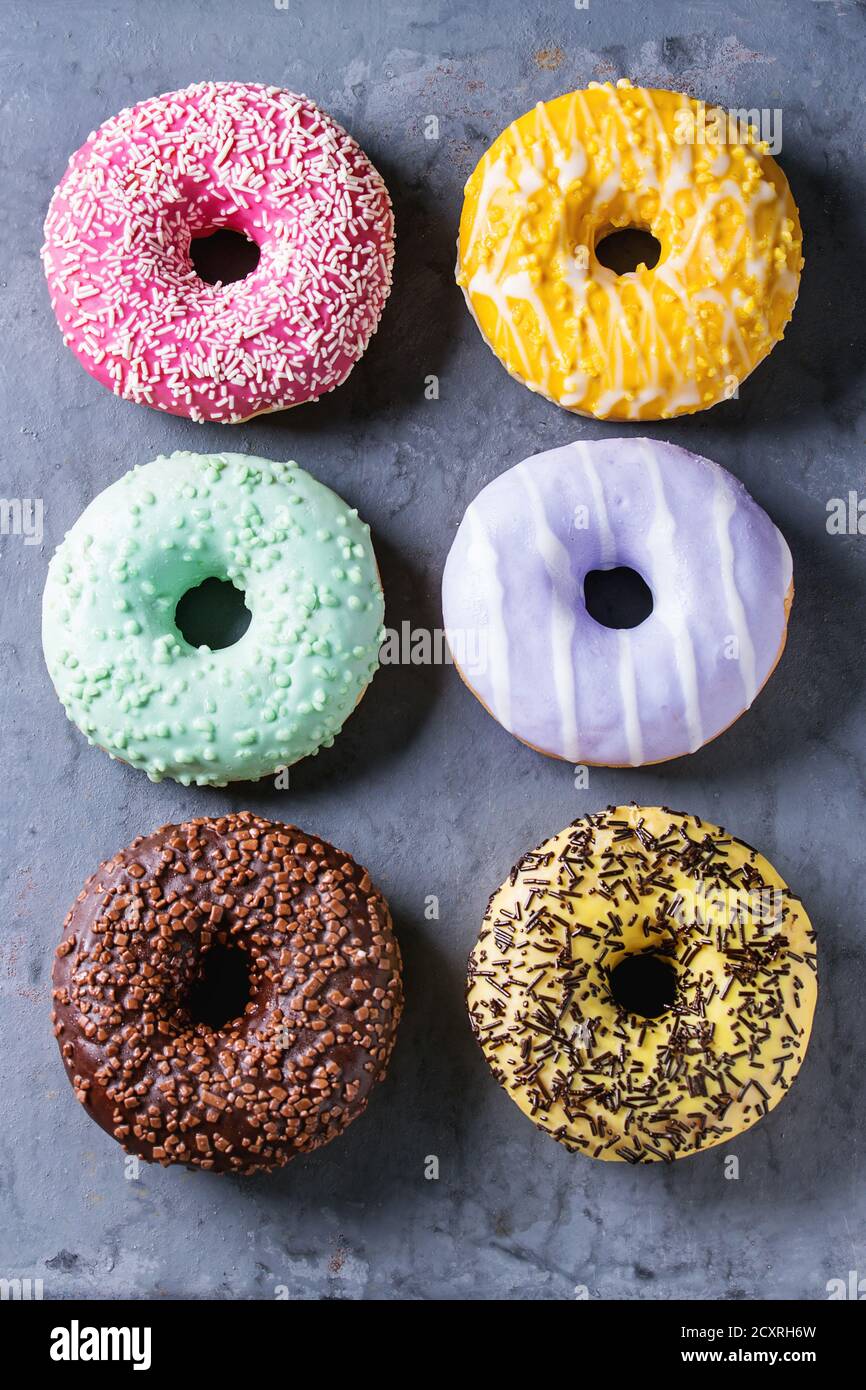 Variety of colorful glazed donuts over gray metal texture background ...