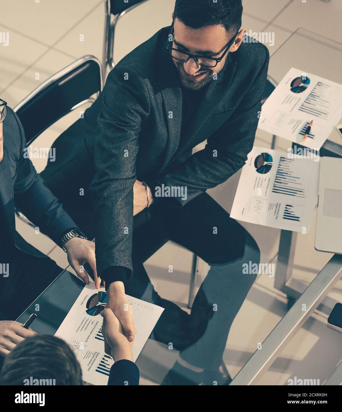 financial partner shake hands over an office Desk Stock Photo - Alamy