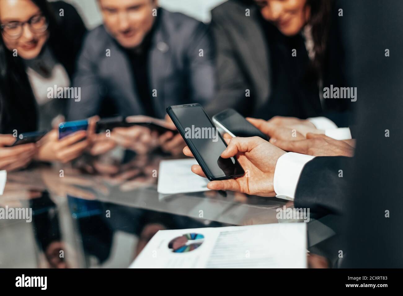 close up . employees with smartphones sitting at the Desk Stock Photo ...