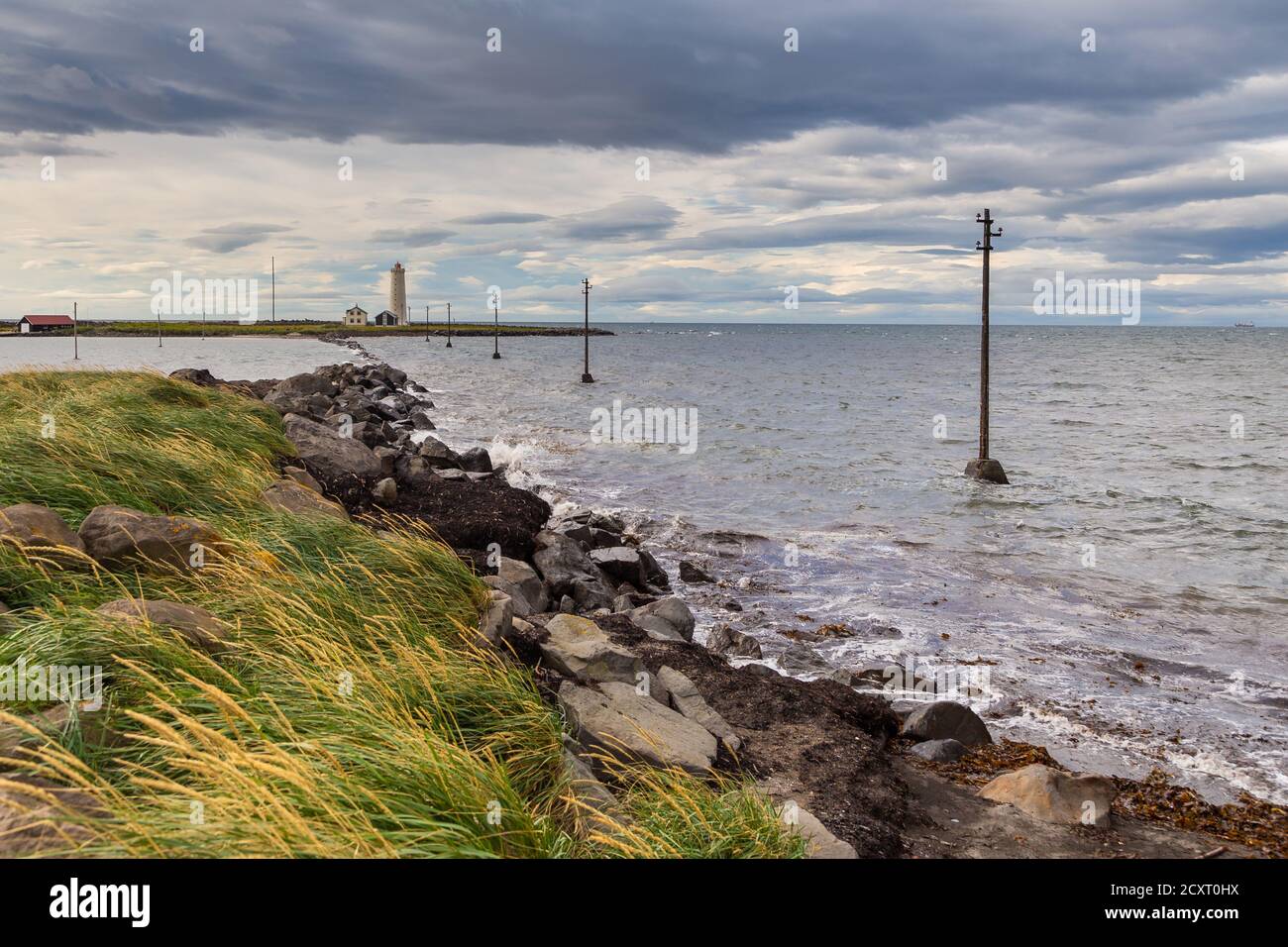 Rocky coast of Faxafloi Bay, lighthouse in the background ...