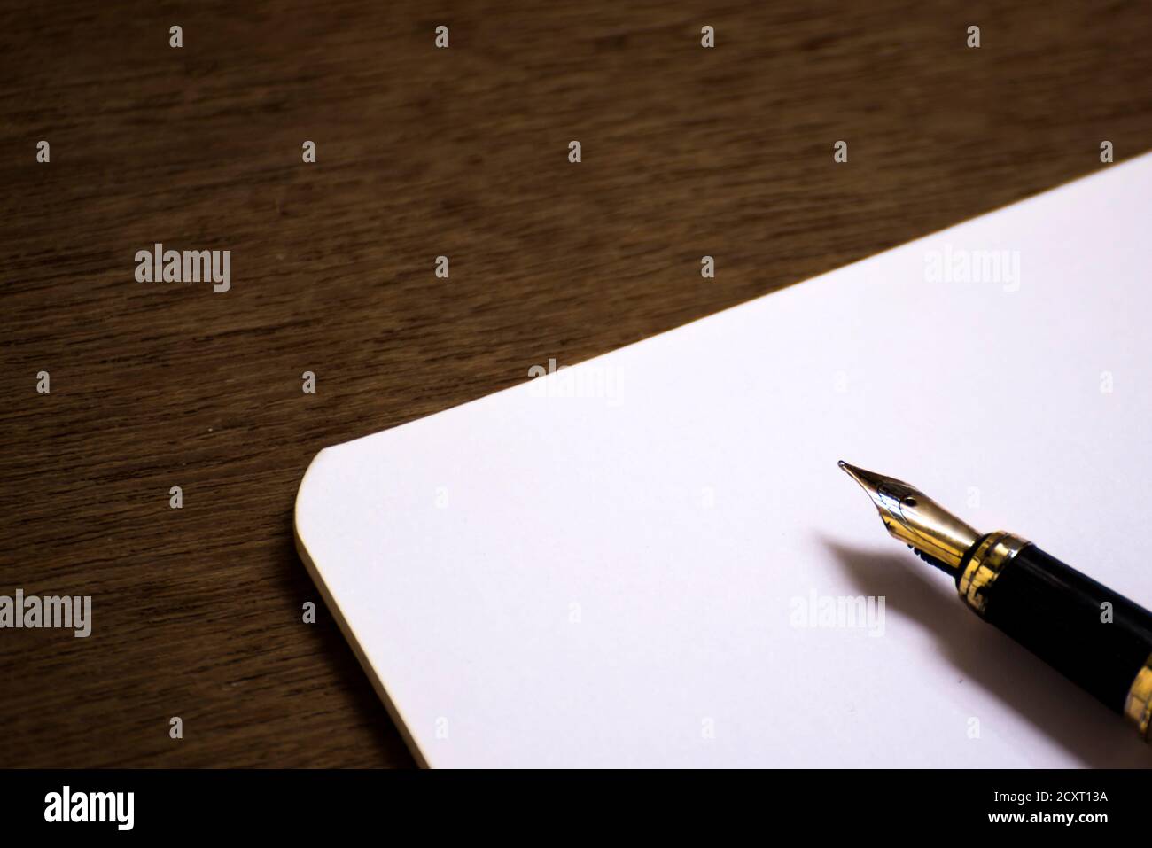 An empty blank white page of a notepad, placed over old wooden ...