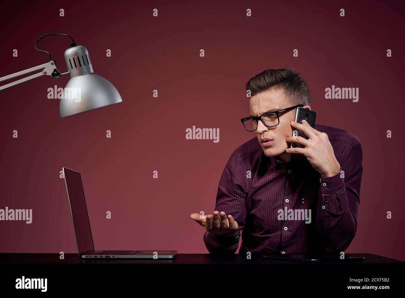 Business man in office and talking on the phone manager red background ...