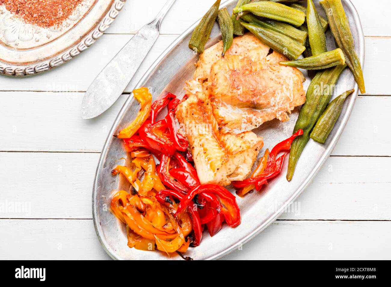 Baked fish with okra and red pepper.Fish grenadier Stock Photo - Alamy