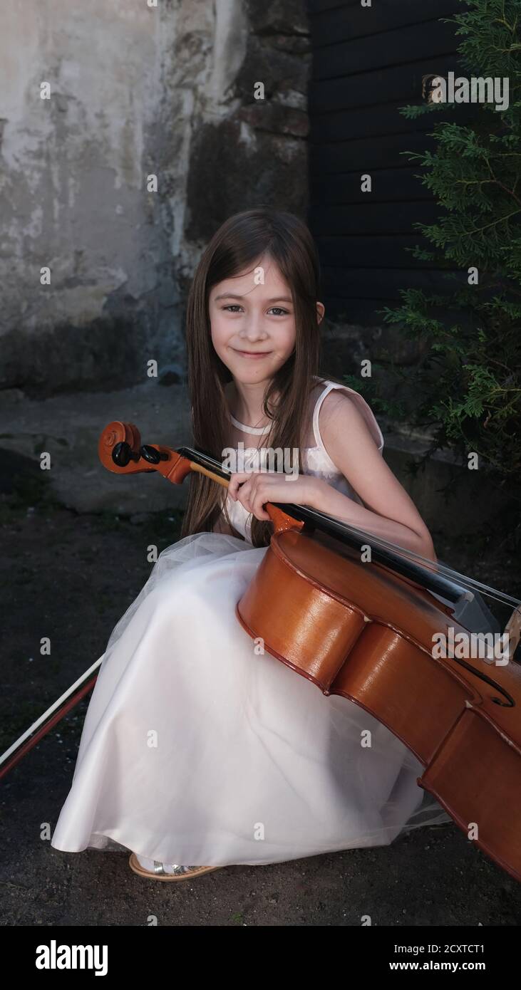 beautiful girl in a pink dress sits with a cello Stock Photo - Alamy