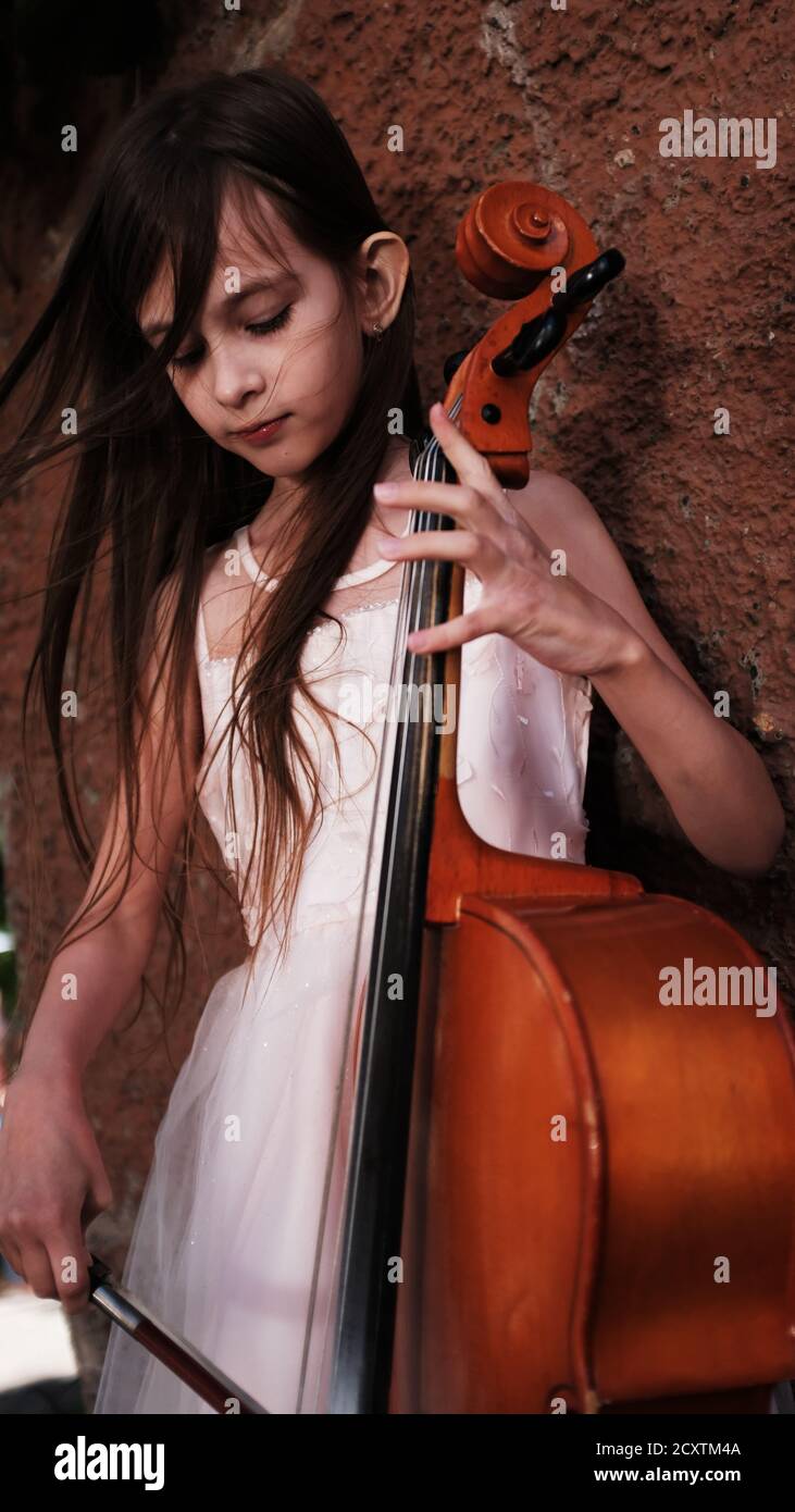 beautiful girl in a pink dress stands with a cello Stock Photo - Alamy