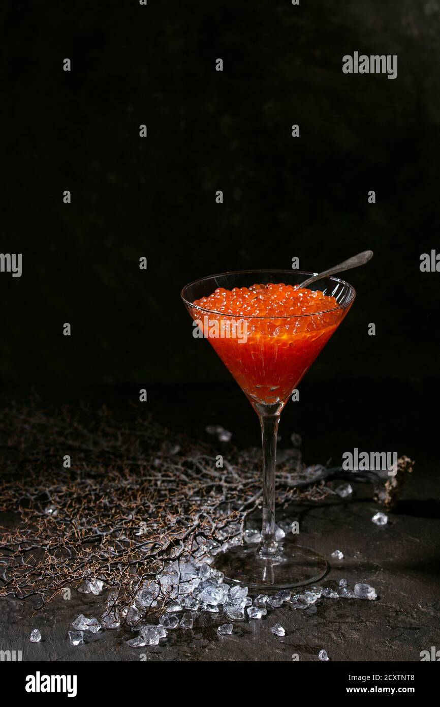 Glass of red caviar on crushed ice over dark background Stock Photo - Alamy