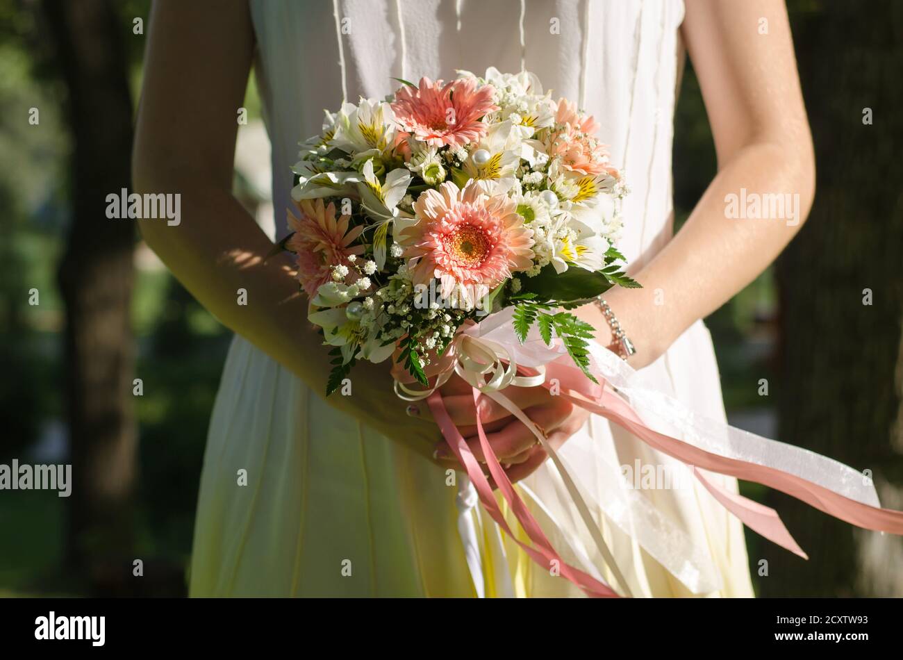Wedding bouquet in the hands of the bride. Sunny day Stock Photo - Alamy
