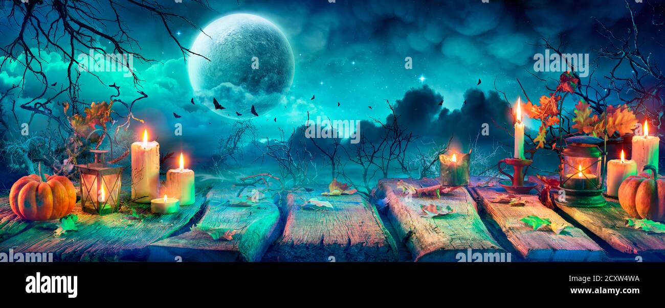 Spooky Halloween Table With Candles And Pumpkins At Night With Full ...