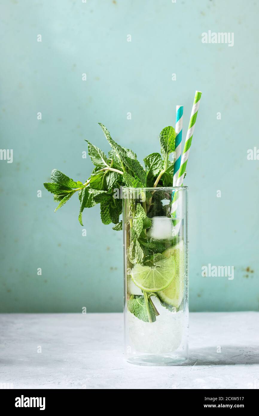 Glass of classic mojito cocktail with fresh mint, limes, crushed ice ...