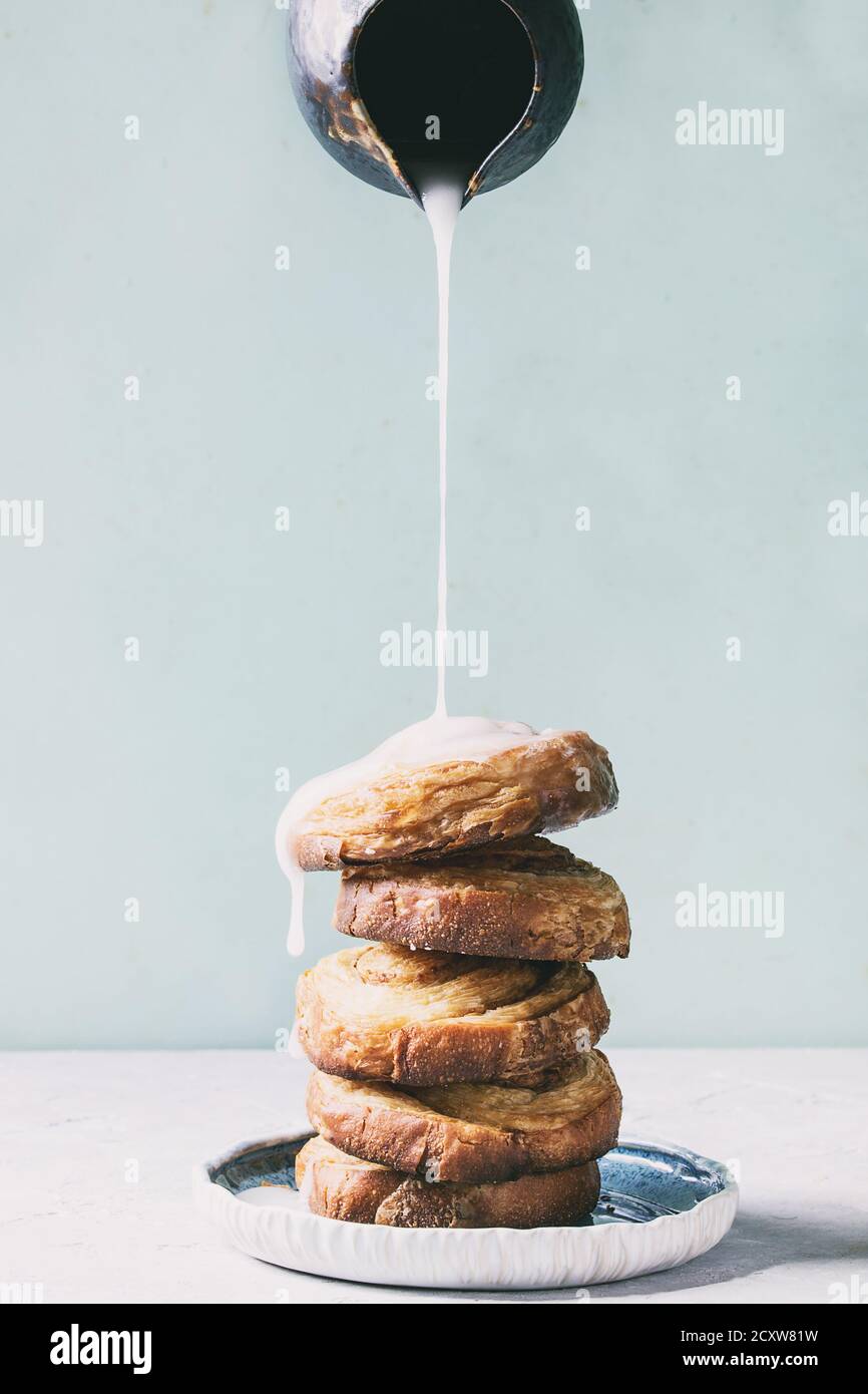 Stack of homemade glazed puff pastry cinnamon rolls with custard and ...